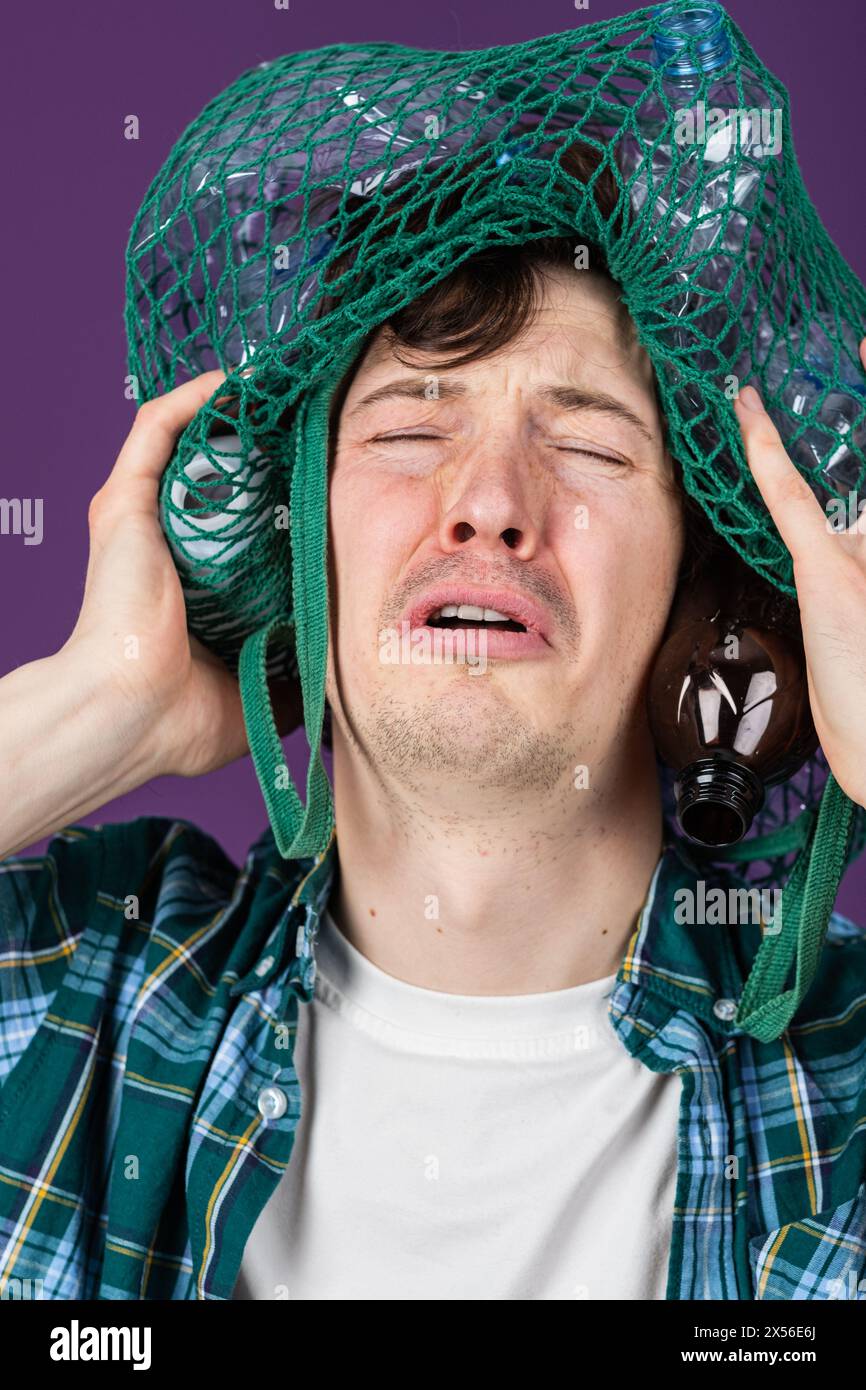 A man grimaces in frustration, his head ensnared in a green net full of ...