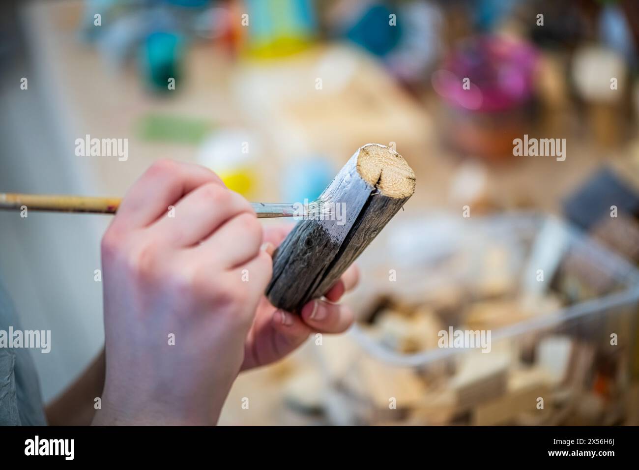 cute teen girl at a master class making a craft from wood, exhibition ...