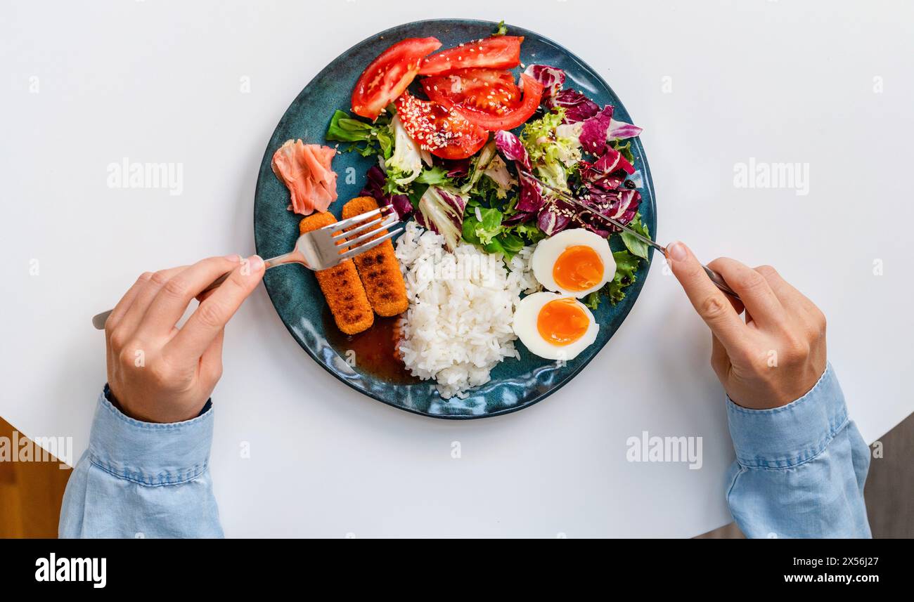 Directly above plate with a healthy and balanced meal and female's ...
