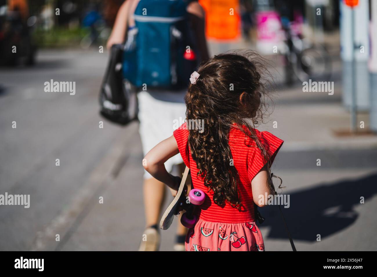 kid walking in the street with her skateboard Stock Photo - Alamy