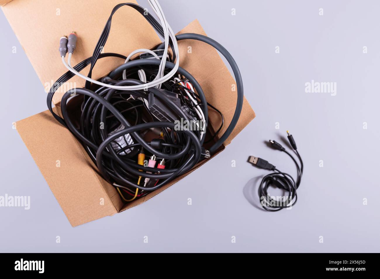 Cardboard box filled with old cables, wires, and button mobile phones ...
