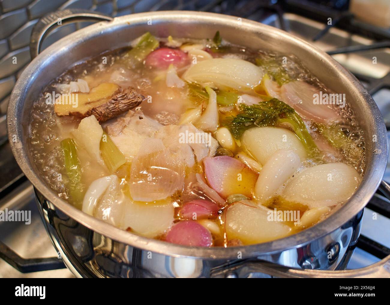 Chicken stock boiling in a pot set upon a stove Stock Photo - Alamy