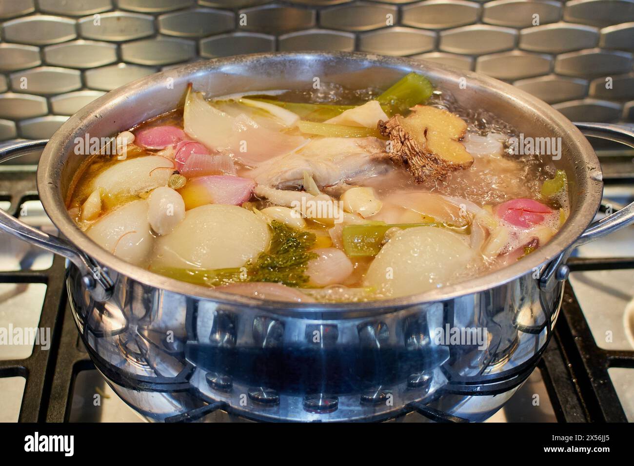 Chicken stock boiling in a pot set upon a stove Stock Photo - Alamy