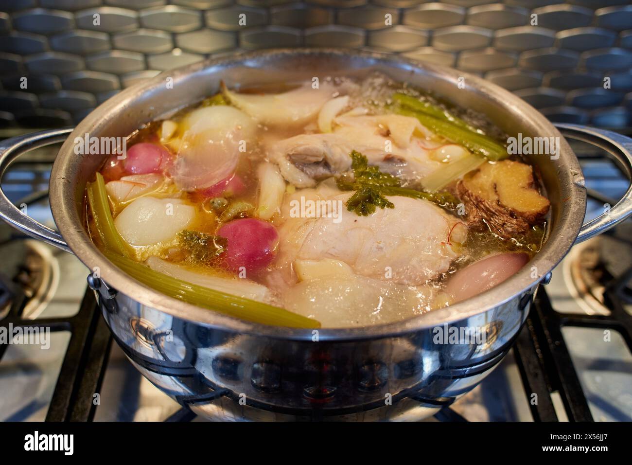 Chicken stock boiling in a pot set upon a stove Stock Photo - Alamy