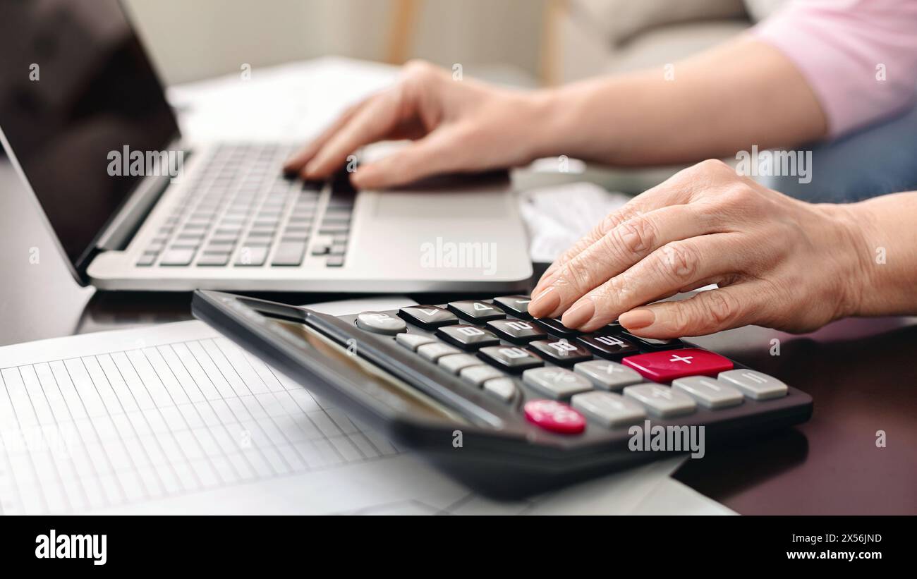 Senior woman with calculator counting dollar money at home Stock Photo ...