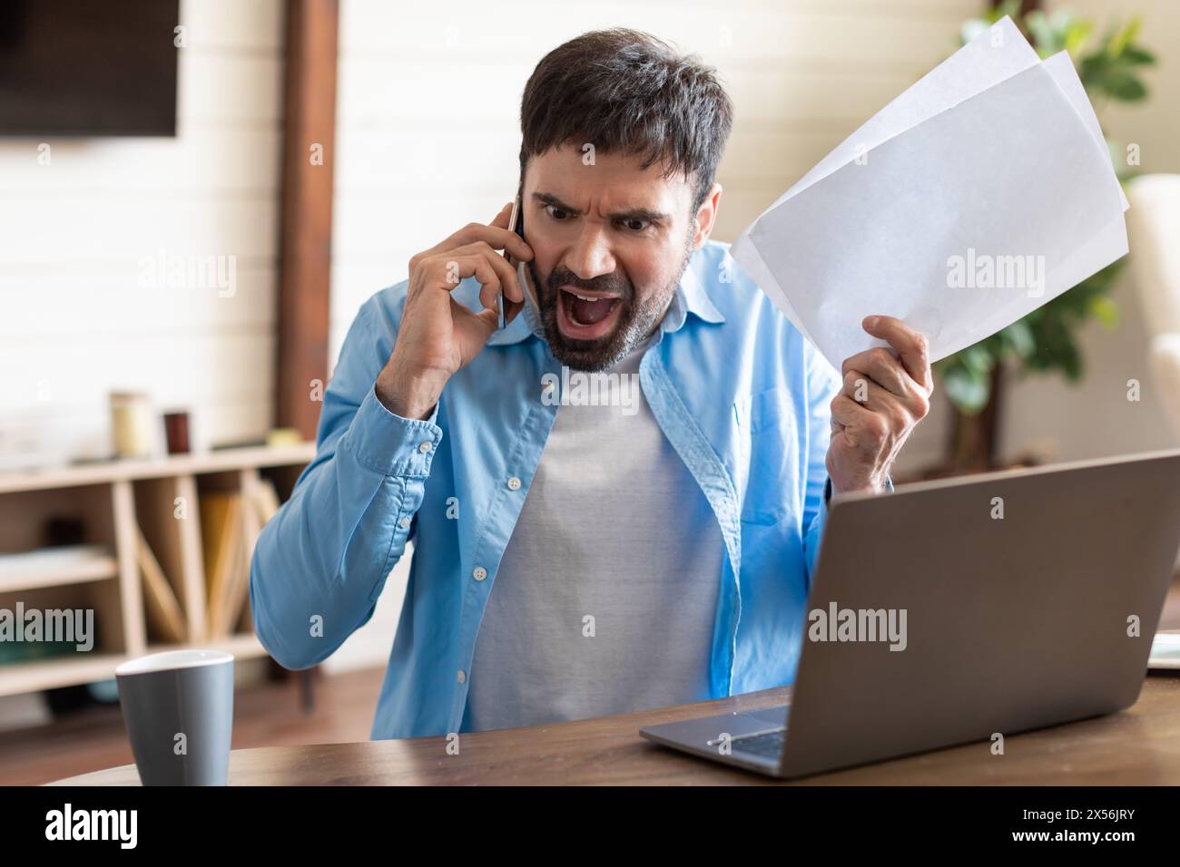 Frustrated Man Arguing on Phone While Holding Documents Stock Photo - Alamy