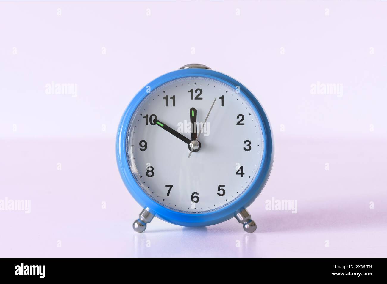 The blue mechanical alarm clock of yesteryear. Close-up. soft pink ...