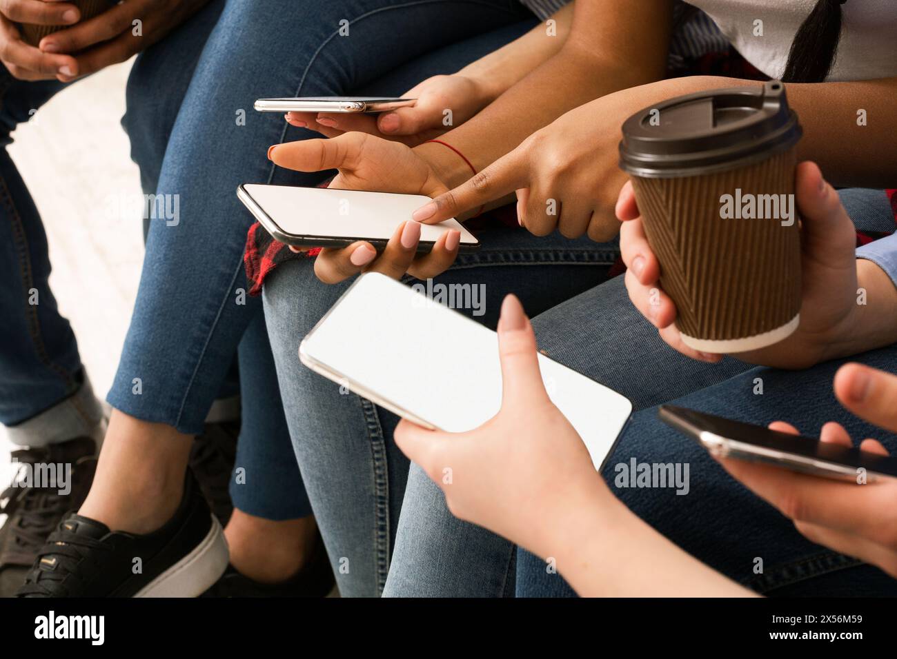 Group of Teenagers Sitting Holding Cell Phones, Cropped Stock Photo - Alamy