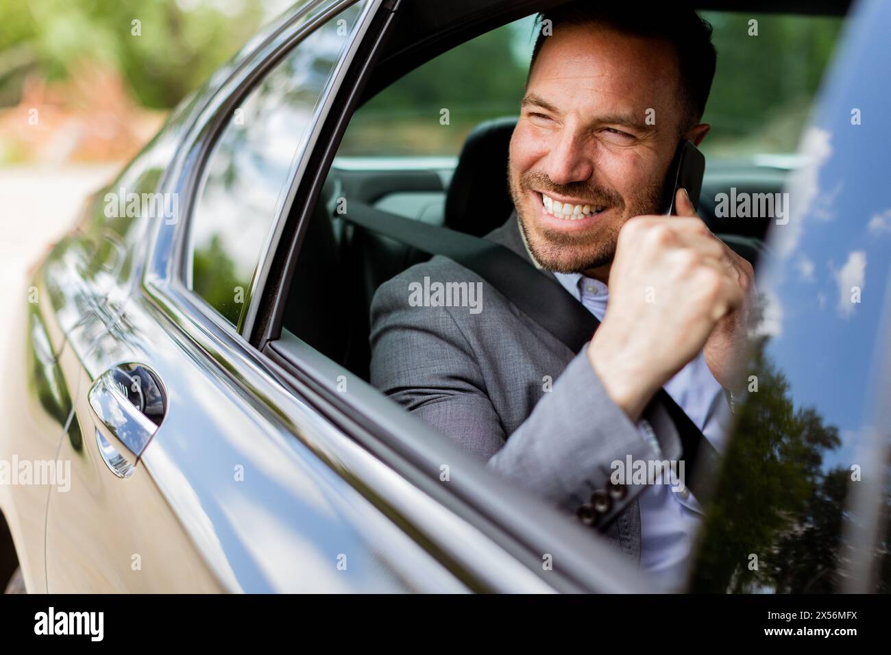 Man chuckles merrily during a car ride, enjoying a lively conversation ...