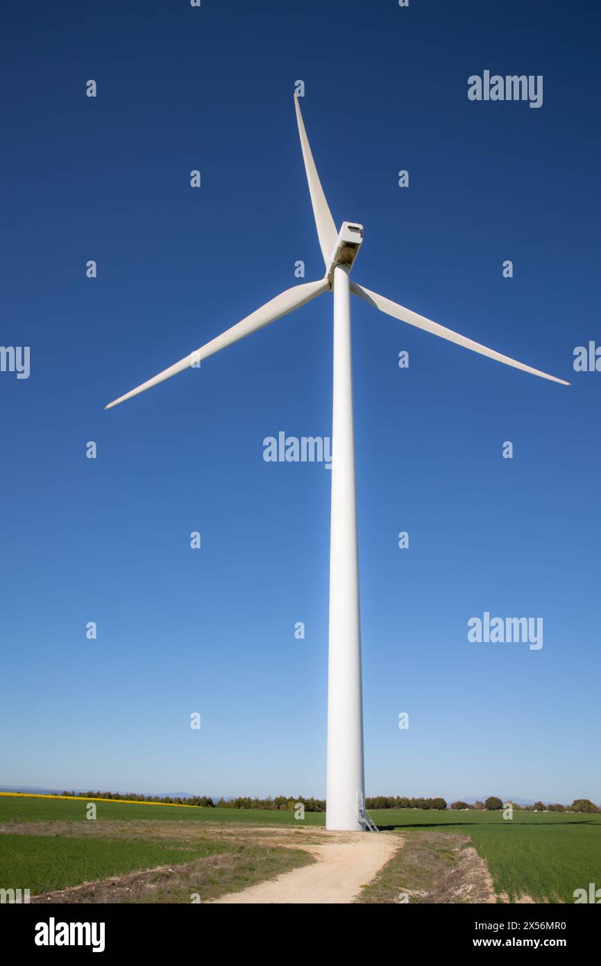 sand road next to a windmill of wind energy in the middle of the ...