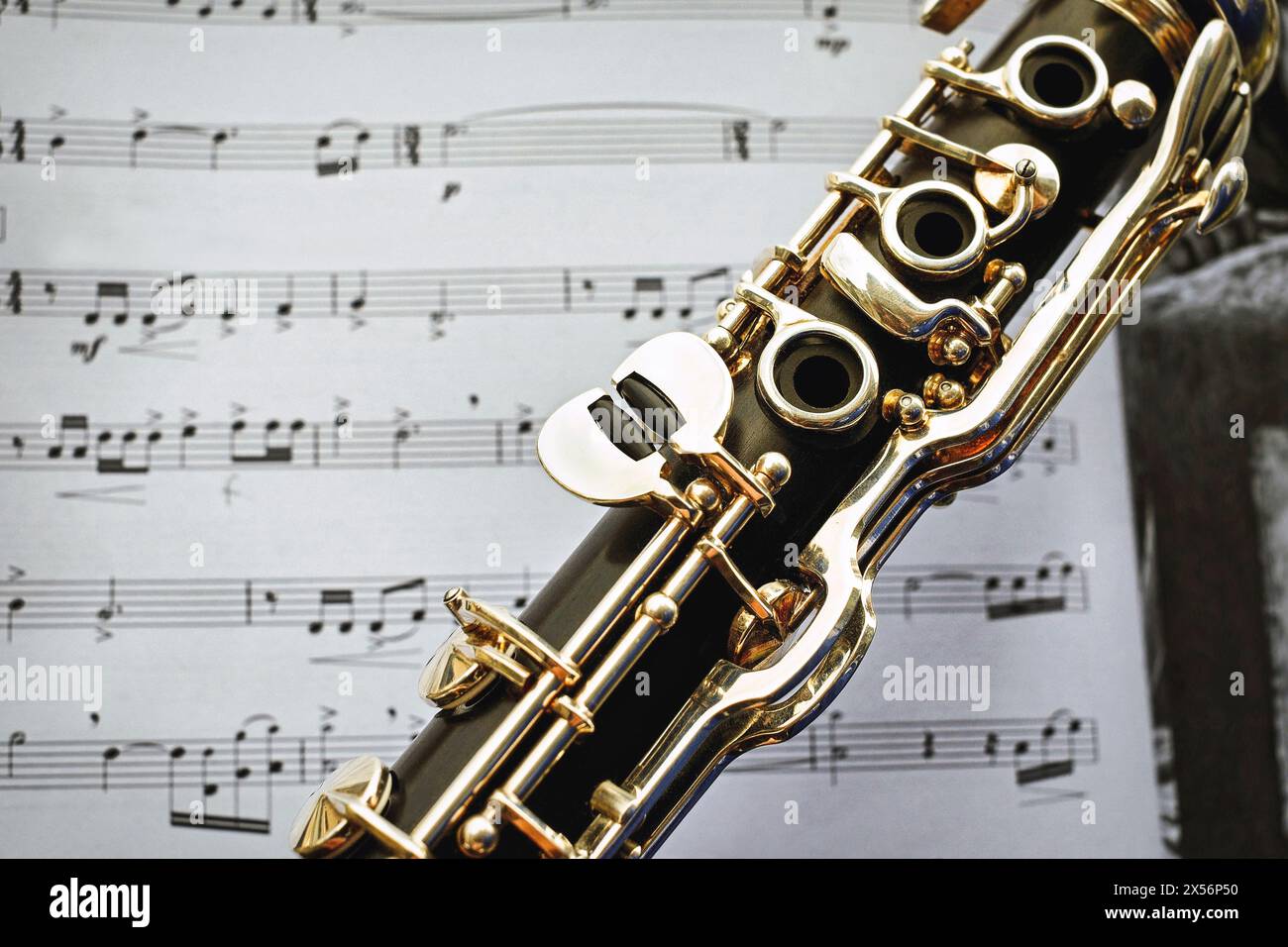 Close-up shot of a flute with musical notes on a page of sheet music in ...