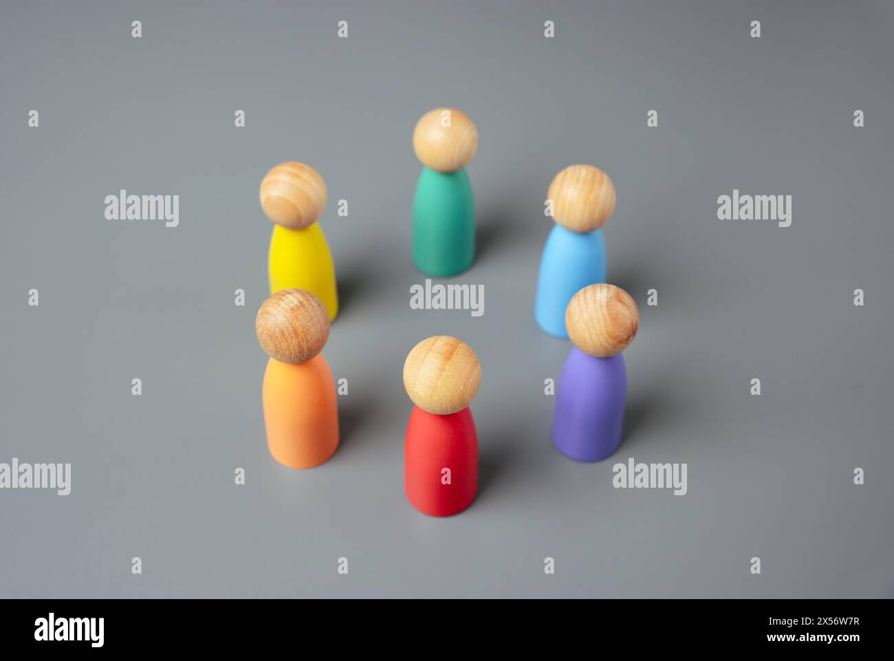 Multi-colored figures of people stand in a circle. Cooperation and ...
