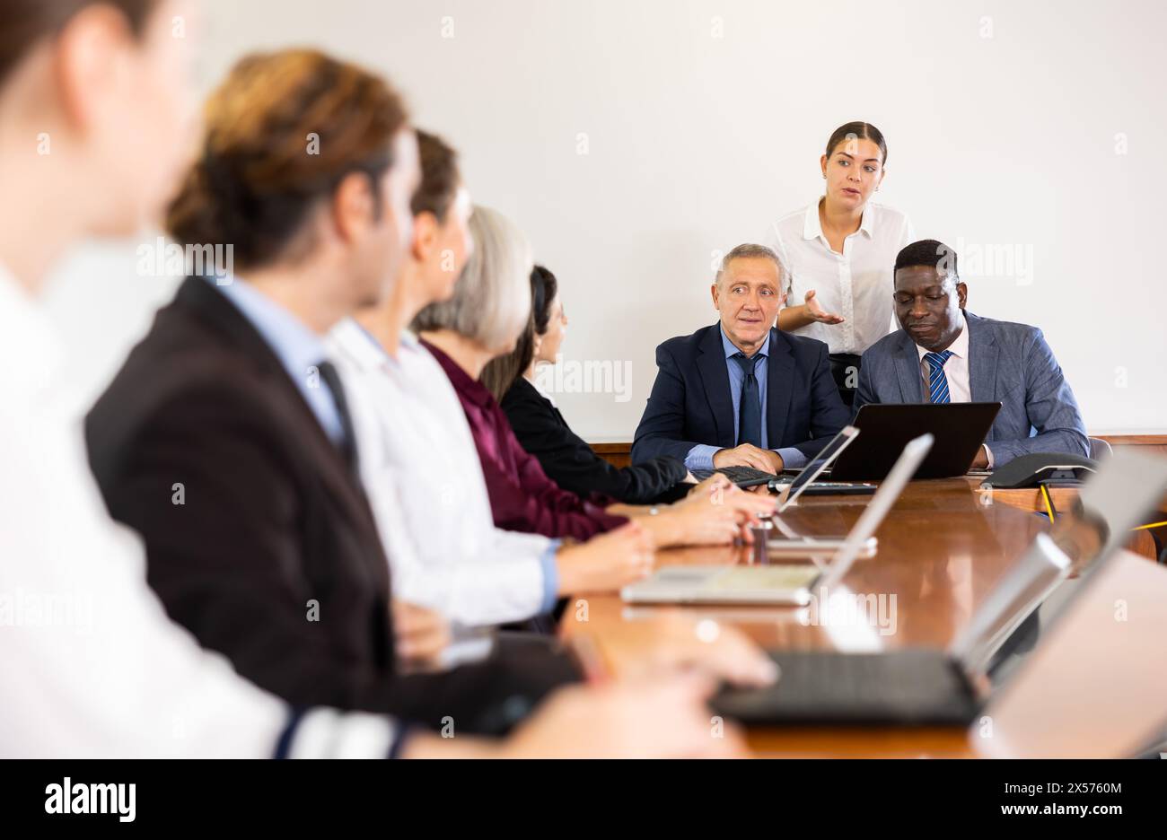 Female manager introduces new company executives to colleagues in ...