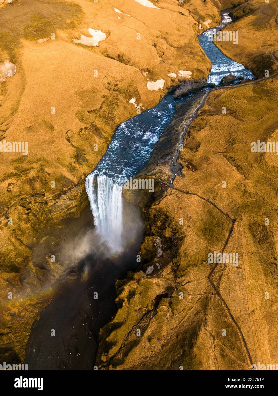 Beautiful skgafoss cascade between hills falling from high frozen ...