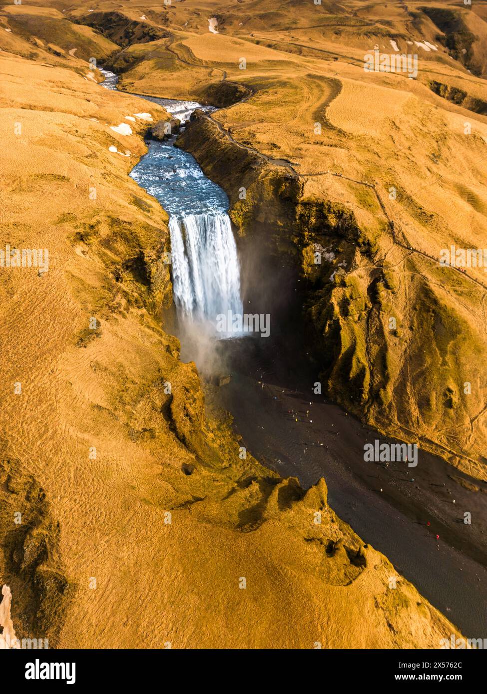 Aerial view of grand glacial skgafoss waterfall gushing down of frigid ...