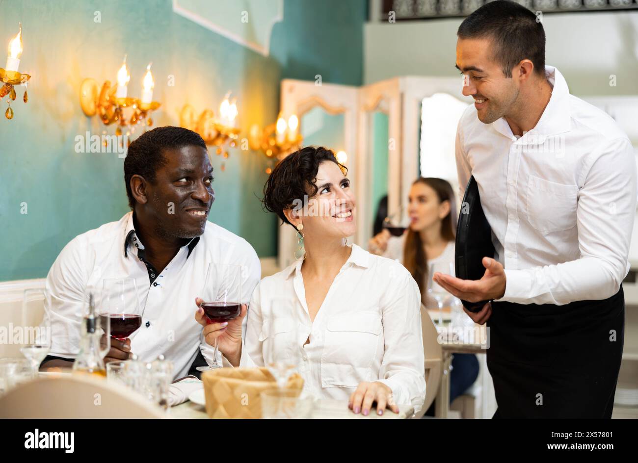 Positive couple having dinner in restaurant and making order Stock ...