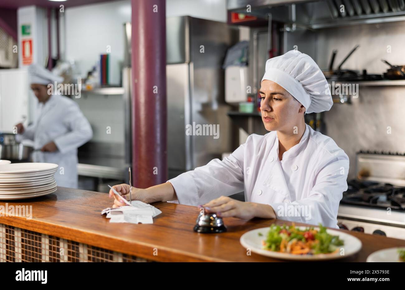 Chef checking orders and giving out meal Stock Photo - Alamy
