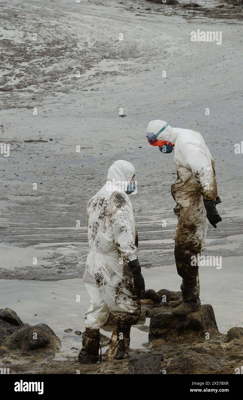 Soldiers dressed with protective clothing cleaning up the oil spill ...
