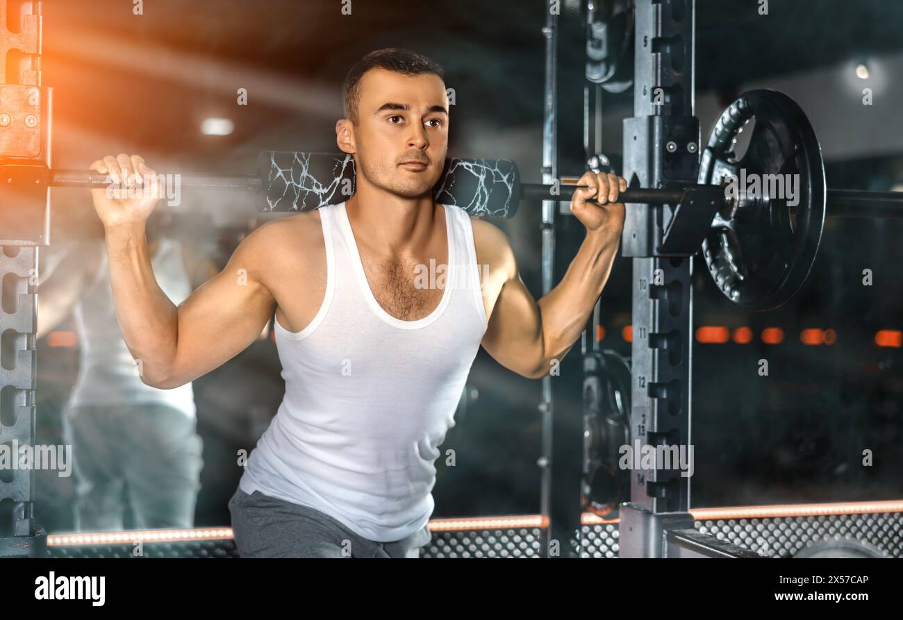 Sporty man performing set of exercises with barbell during intense ...