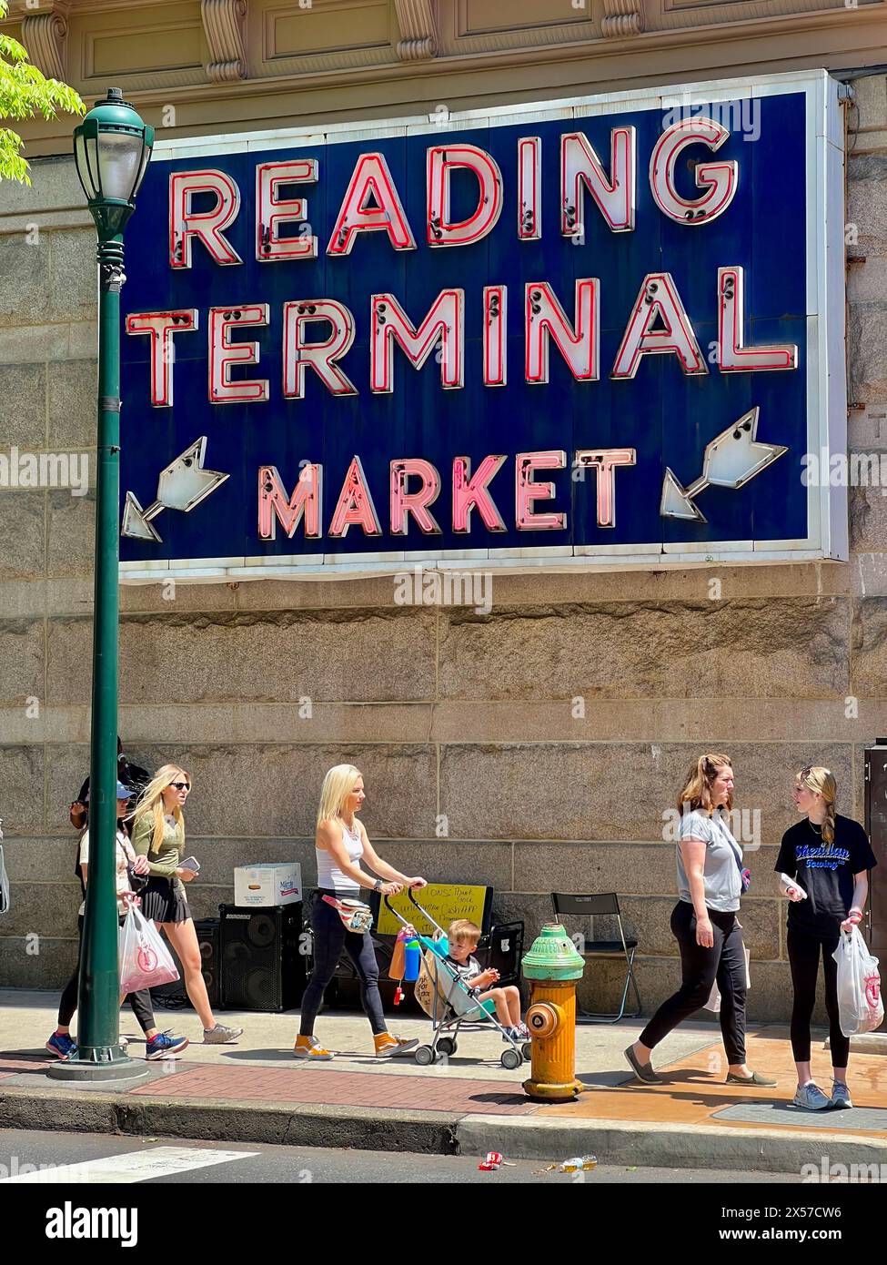 Shoppers walk beneath the Reading Terminal Market sign on 12th Street ...