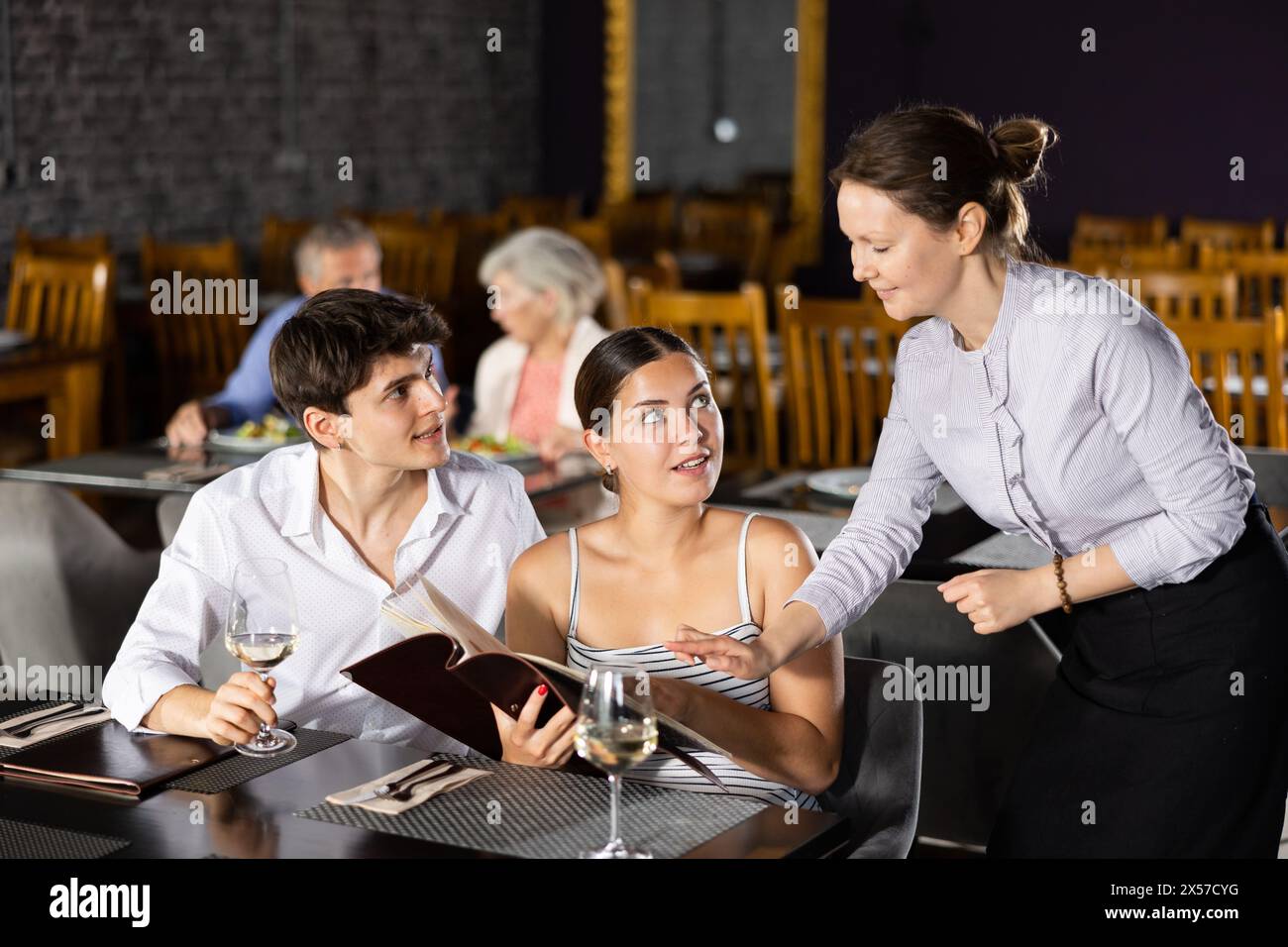 Woman waiter takes order from young couple in restaurant Stock Photo ...
