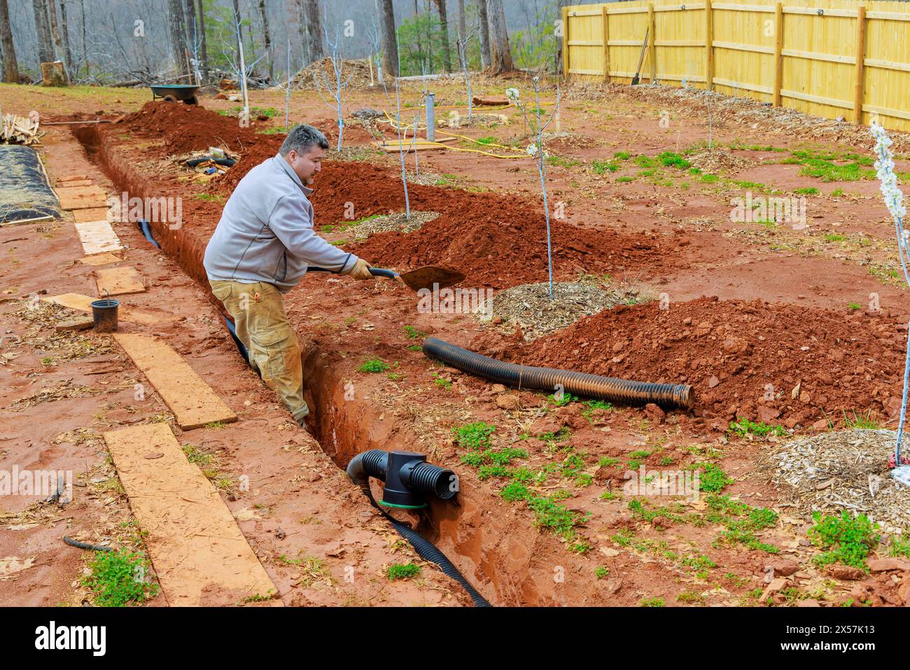 Installing storm drainage pipe into trench drain in order to drain ...