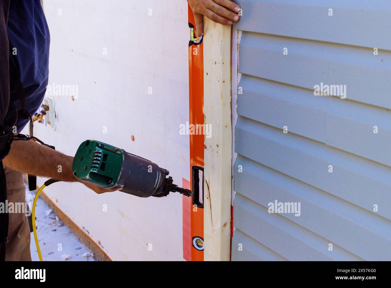 Installing beams with an air nail hammer while nailing wooden frames ...