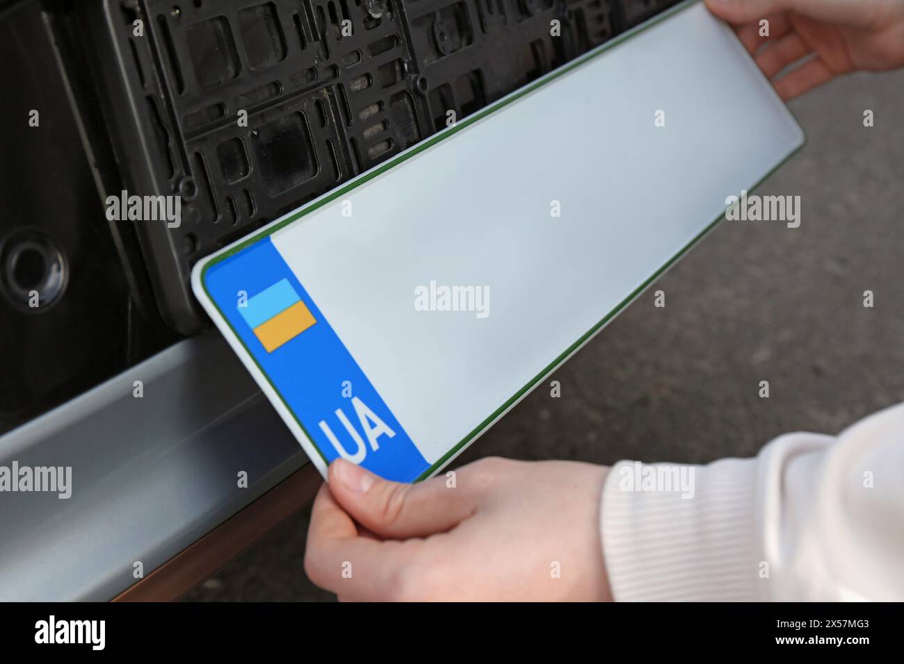 Woman installing vehicle registration plate outdoors, closeup Stock ...