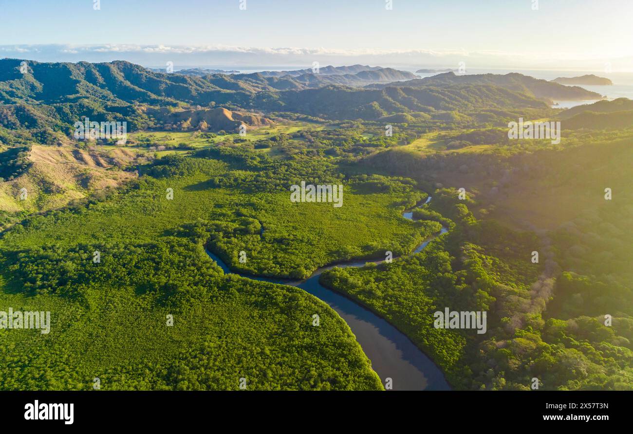 Aerial view of a winding river meandering through a green hilly ...