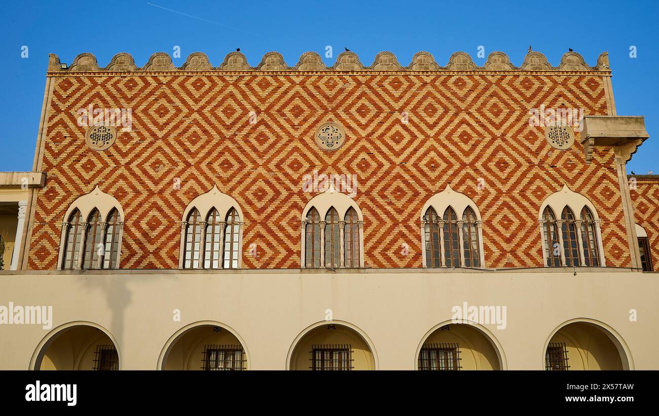 A historic building with a red and white pattern and battlements on the ...