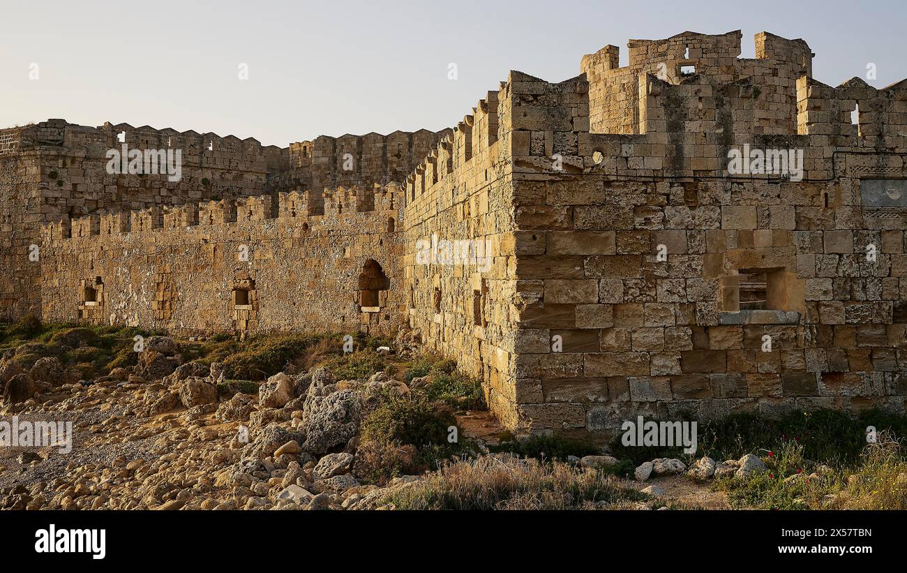Long stone walls of an old fortress in the warm glow of the rising sun ...
