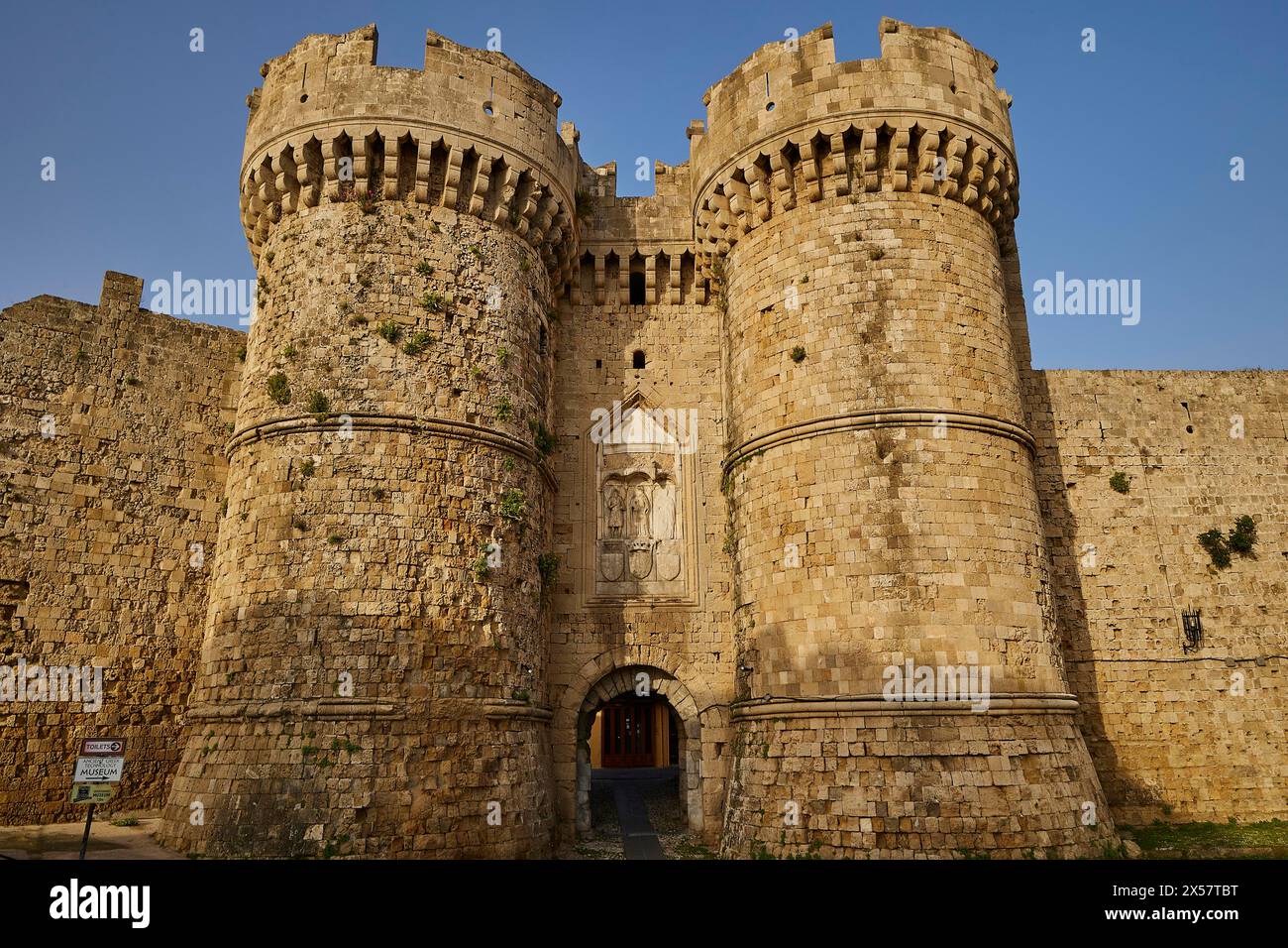 Old-fashioned entrance to a stone castle with tower and entrance gate ...