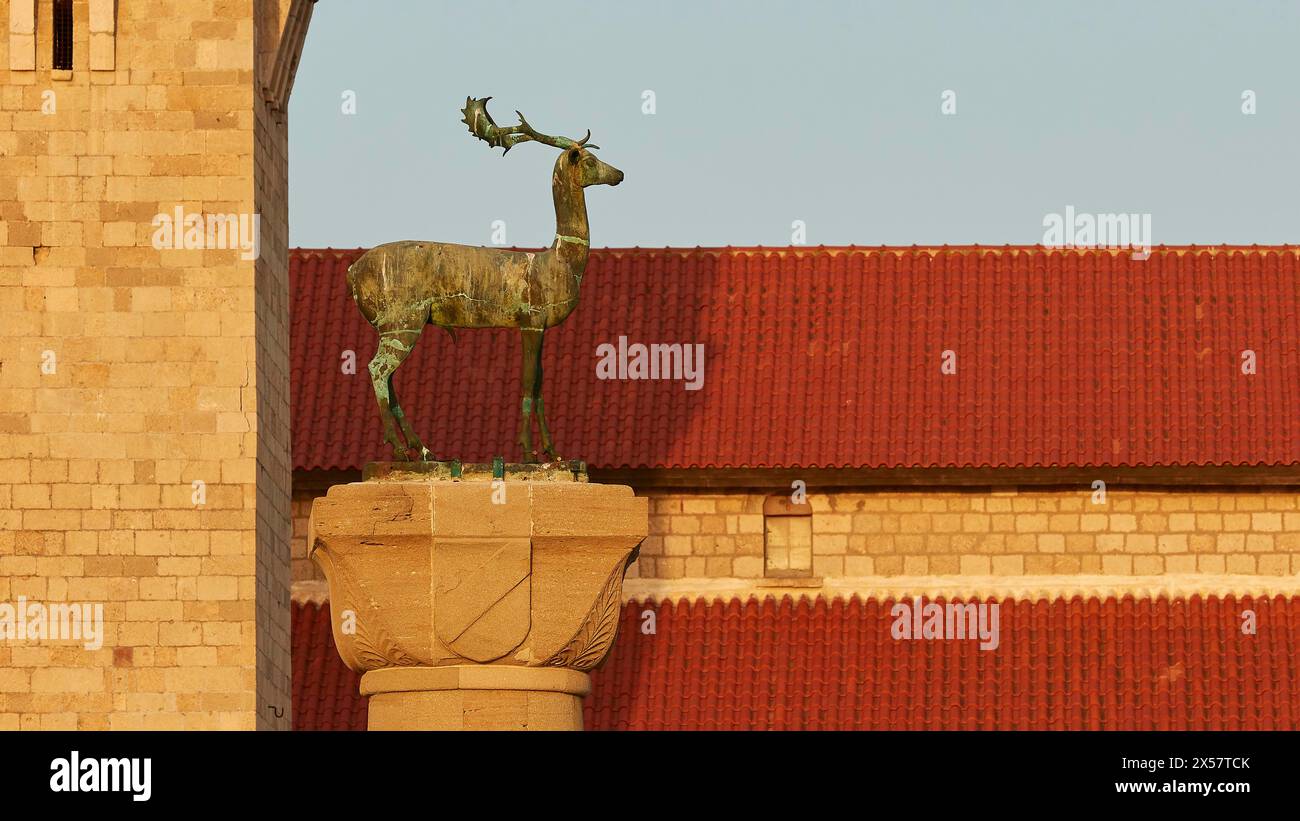 Bronze statue of a Deer in front of a building in the warm morning ...
