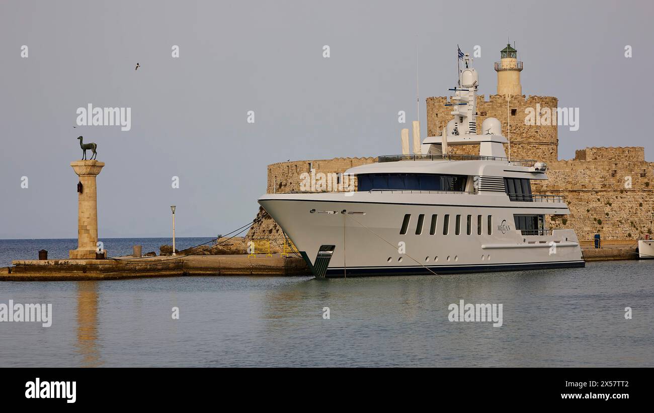 Modern white yacht in front of historic fortress and lighthouse under ...