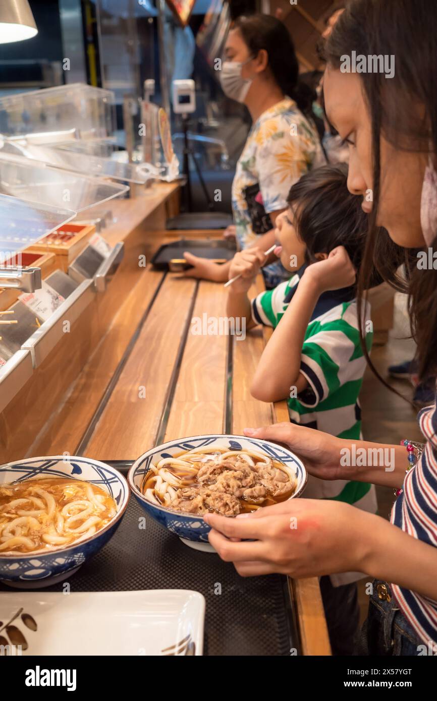 Asian family, mother and two children ordering dinner in Japanese ...