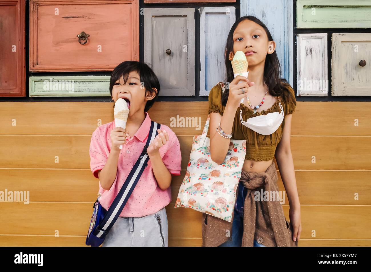 Southeast Asian children, boy and girl enjoy eating ice cream cones together at mall Stock Photo ...