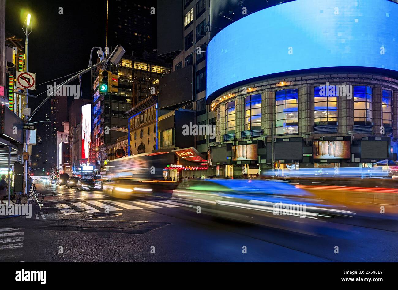 Busy intersection with cars, buses and taxis driving on 42nd Street ...