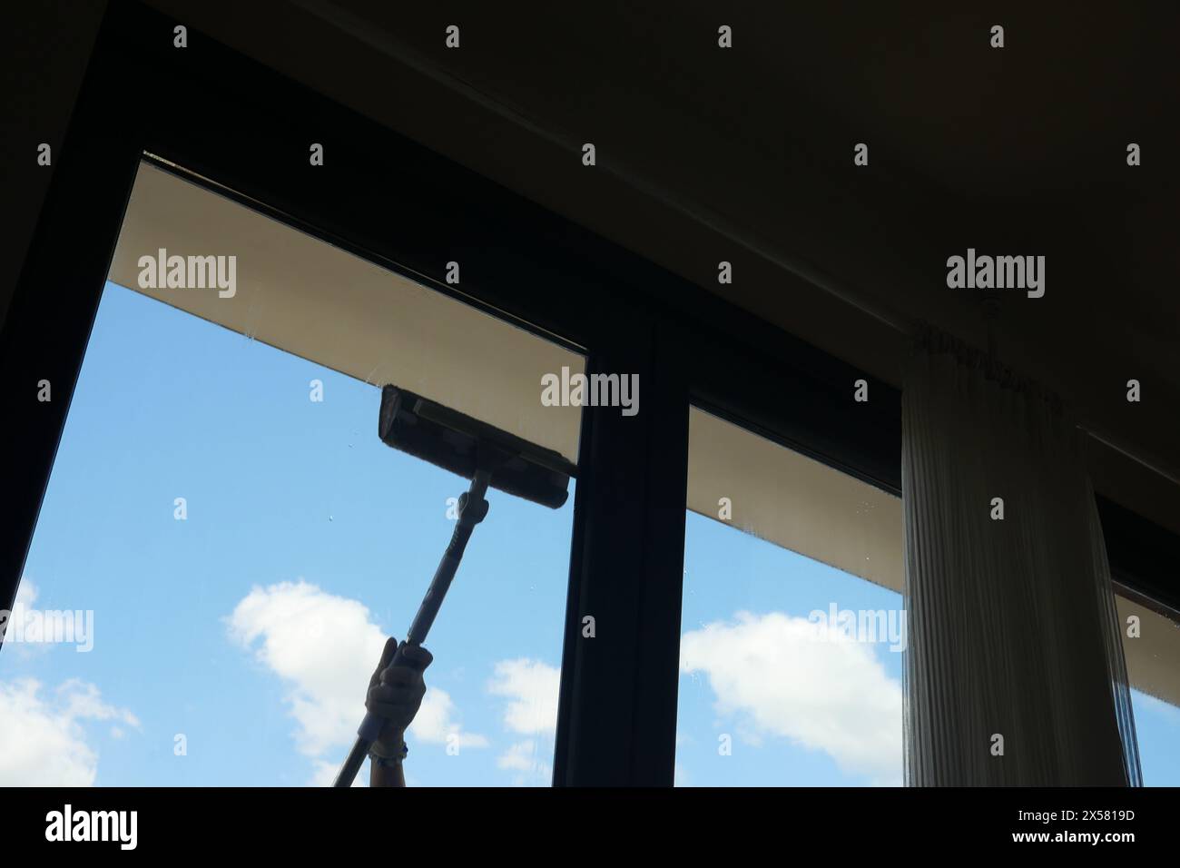 Rubber squeegee cleans a soaped window Stock Photo - Alamy
