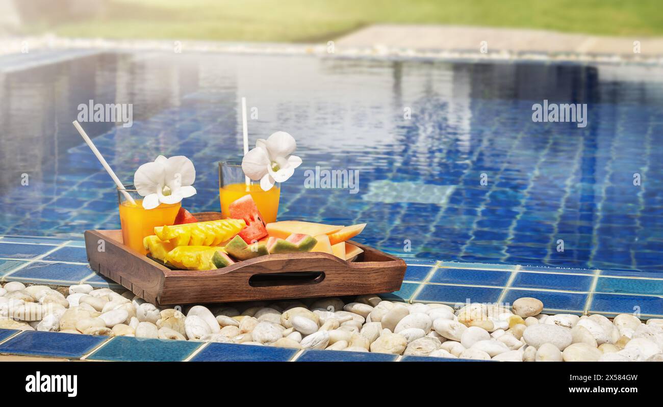 Tray with tropical fruits and juices near the pool on vacation Stock ...