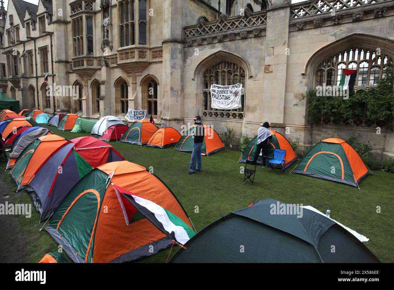 Protesters occupy their newly created camp while a banner flies above ...