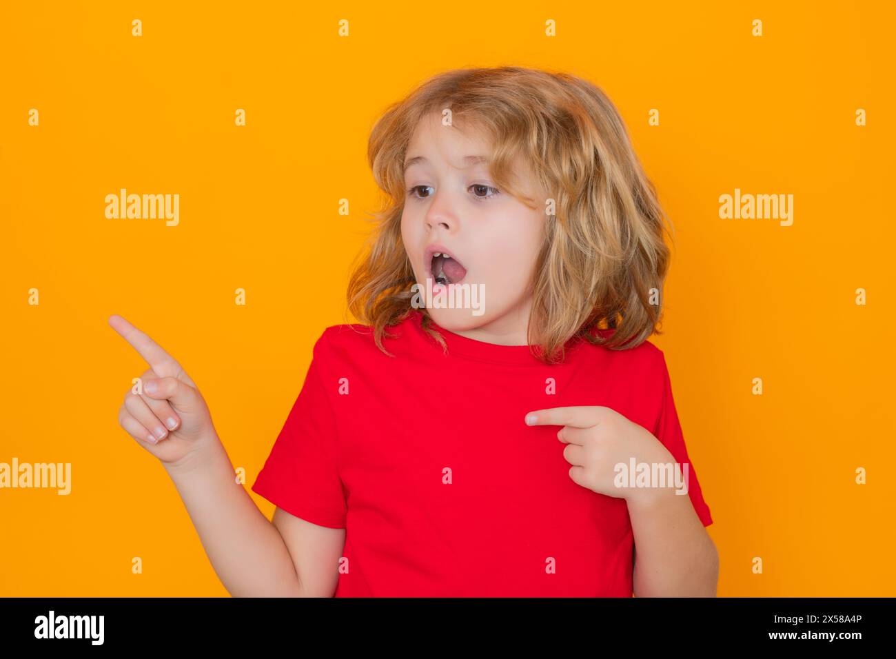 Portrait of child boy pointing away finger on yellow background. Child ...