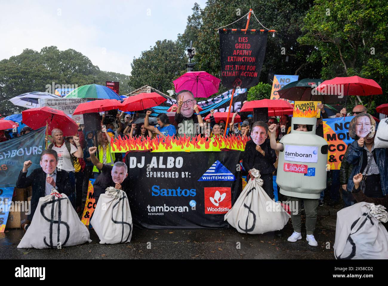 Protesters seen holding bags with dollar signs and wearing masks of ...
