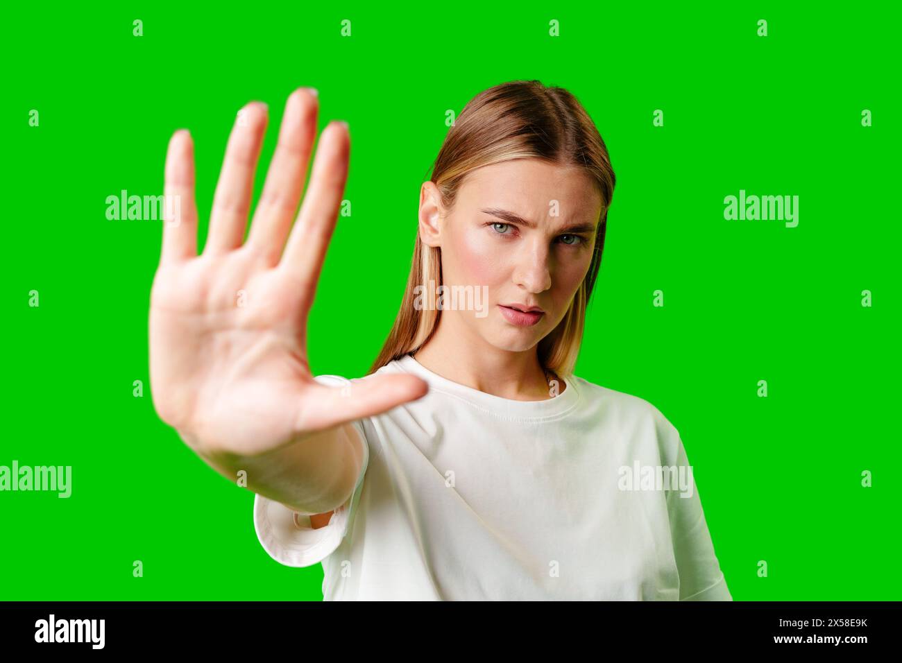 Young Woman Making Stop Sign Gesture on green background Stock Photo ...