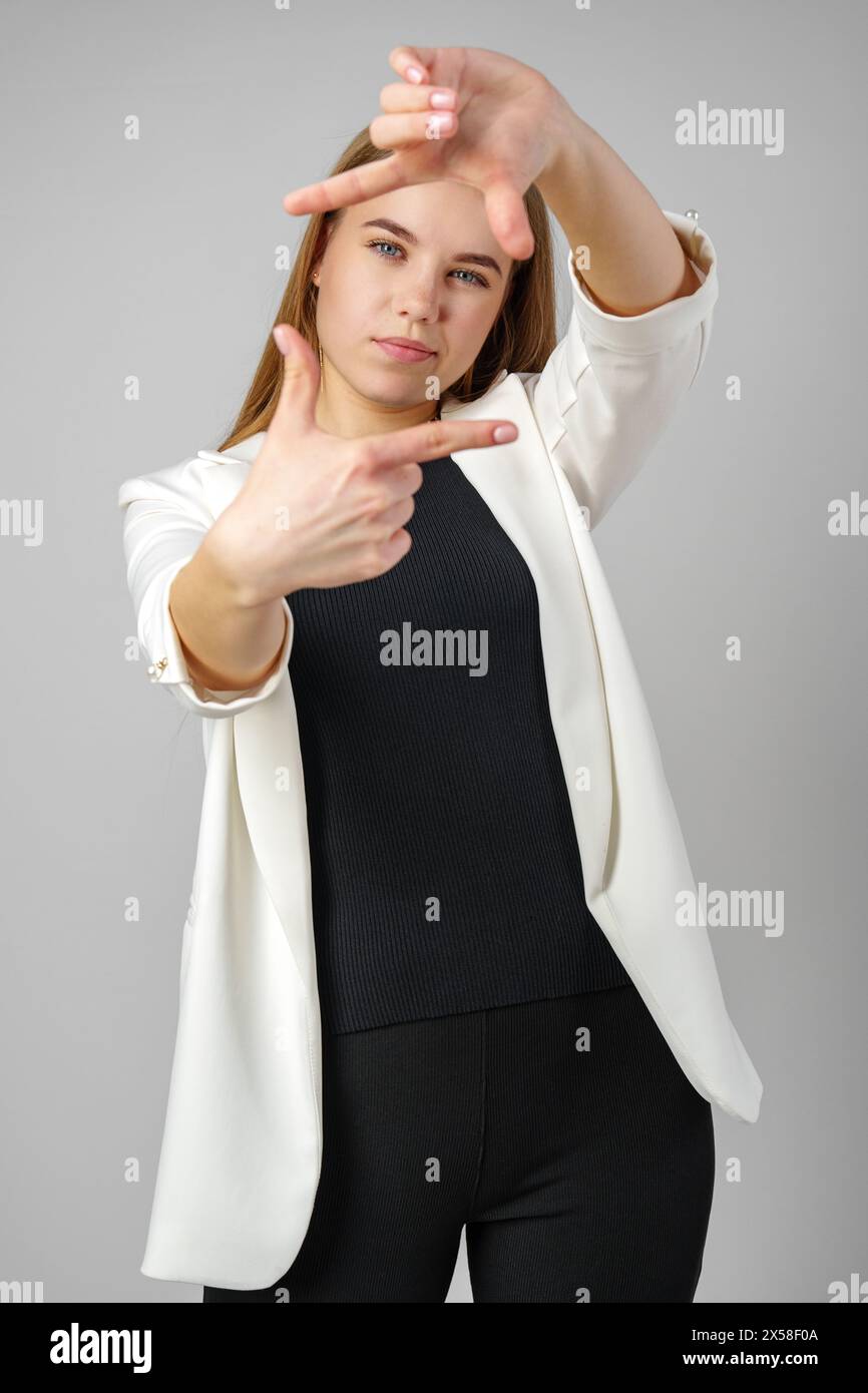 Young Woman Making Frame Gesture With Hands Against a Neutral ...