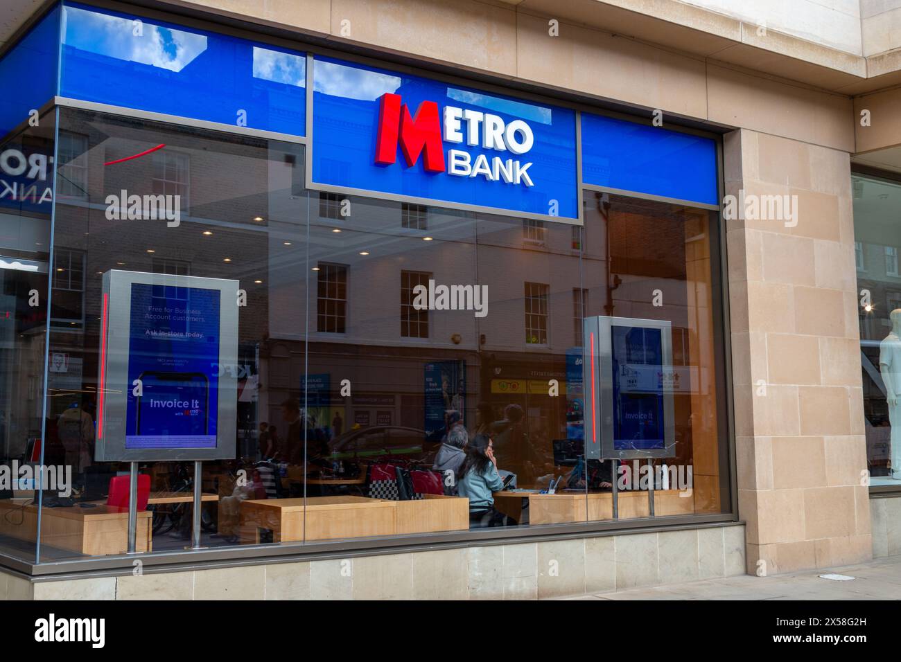 Exterior view of Metro Bank branch with blue signage and customers ...
