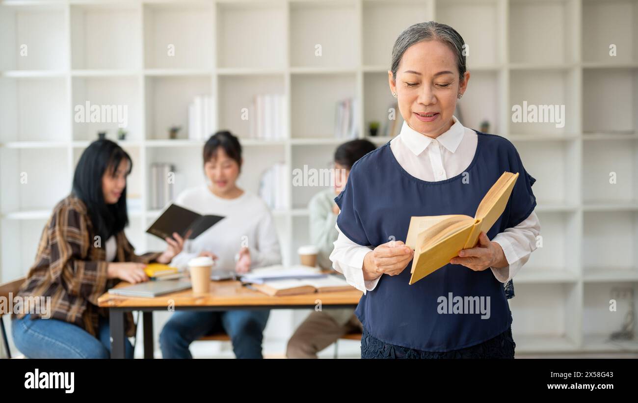 A portrait of a smiling, satisfied senior Asian female teacher ...