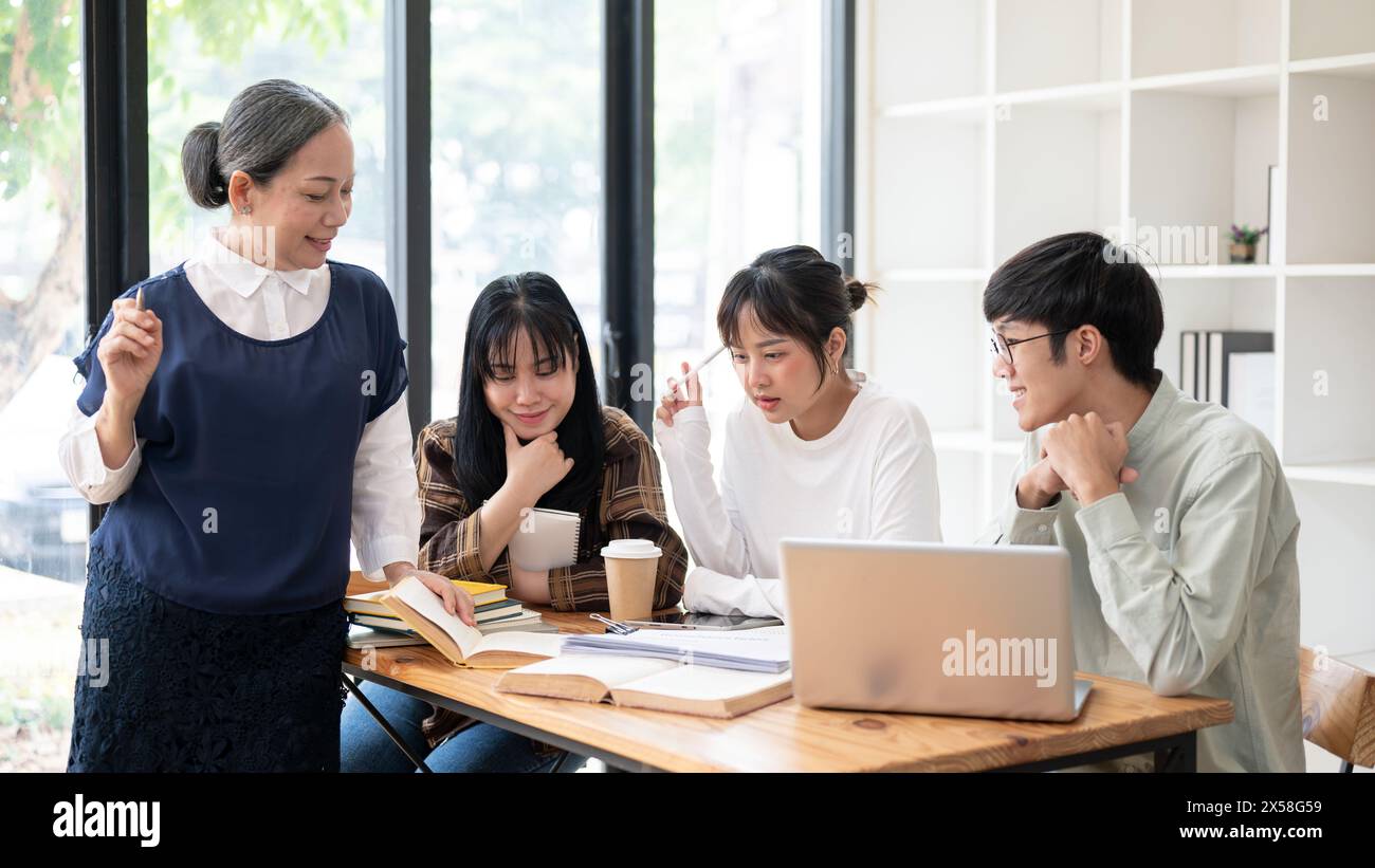 A positive and kind senior Asian female teacher is teaching her ...