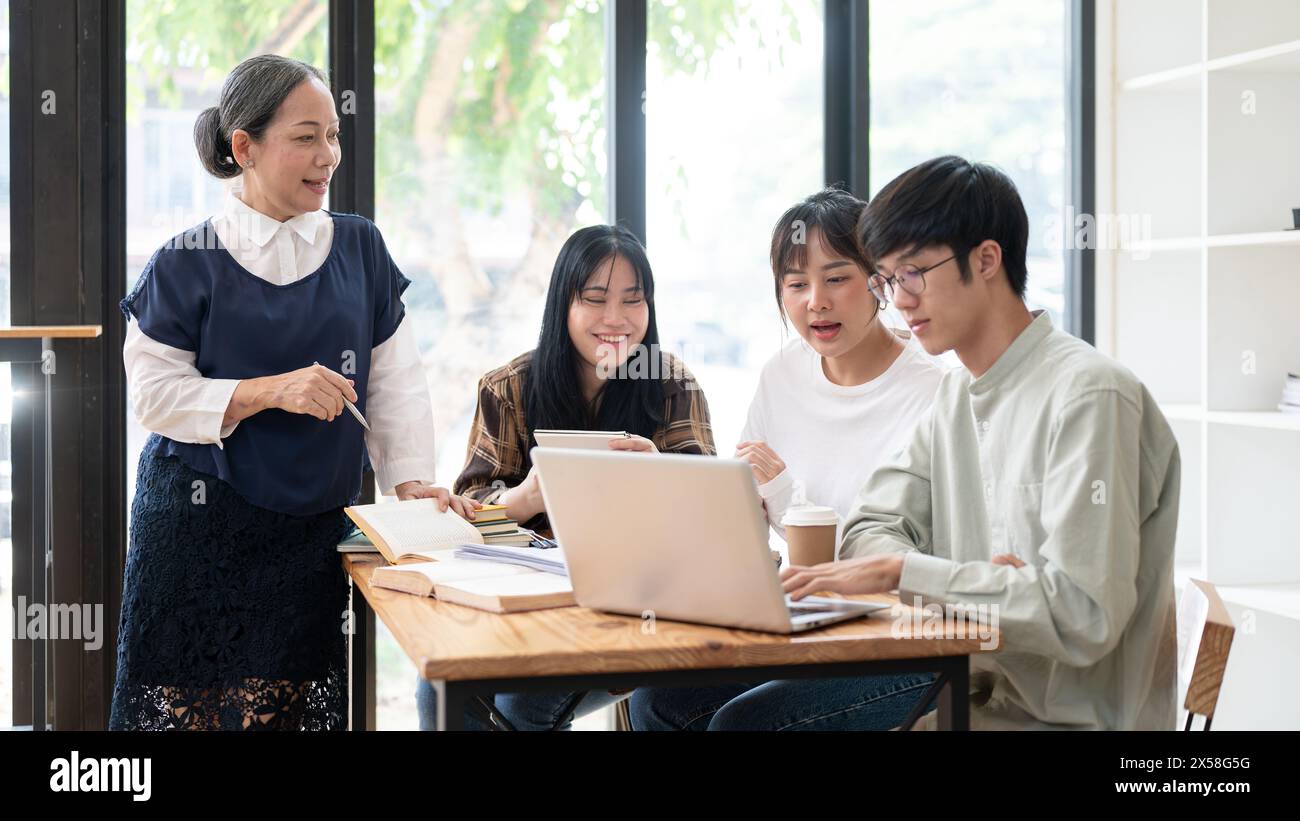A positive and kind senior Asian female teacher is teaching her ...