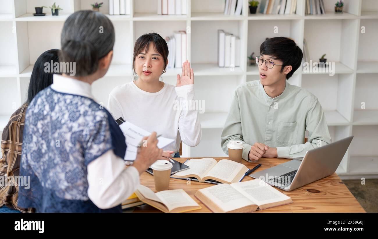 A positive young Asian female university student is raising her hand ...