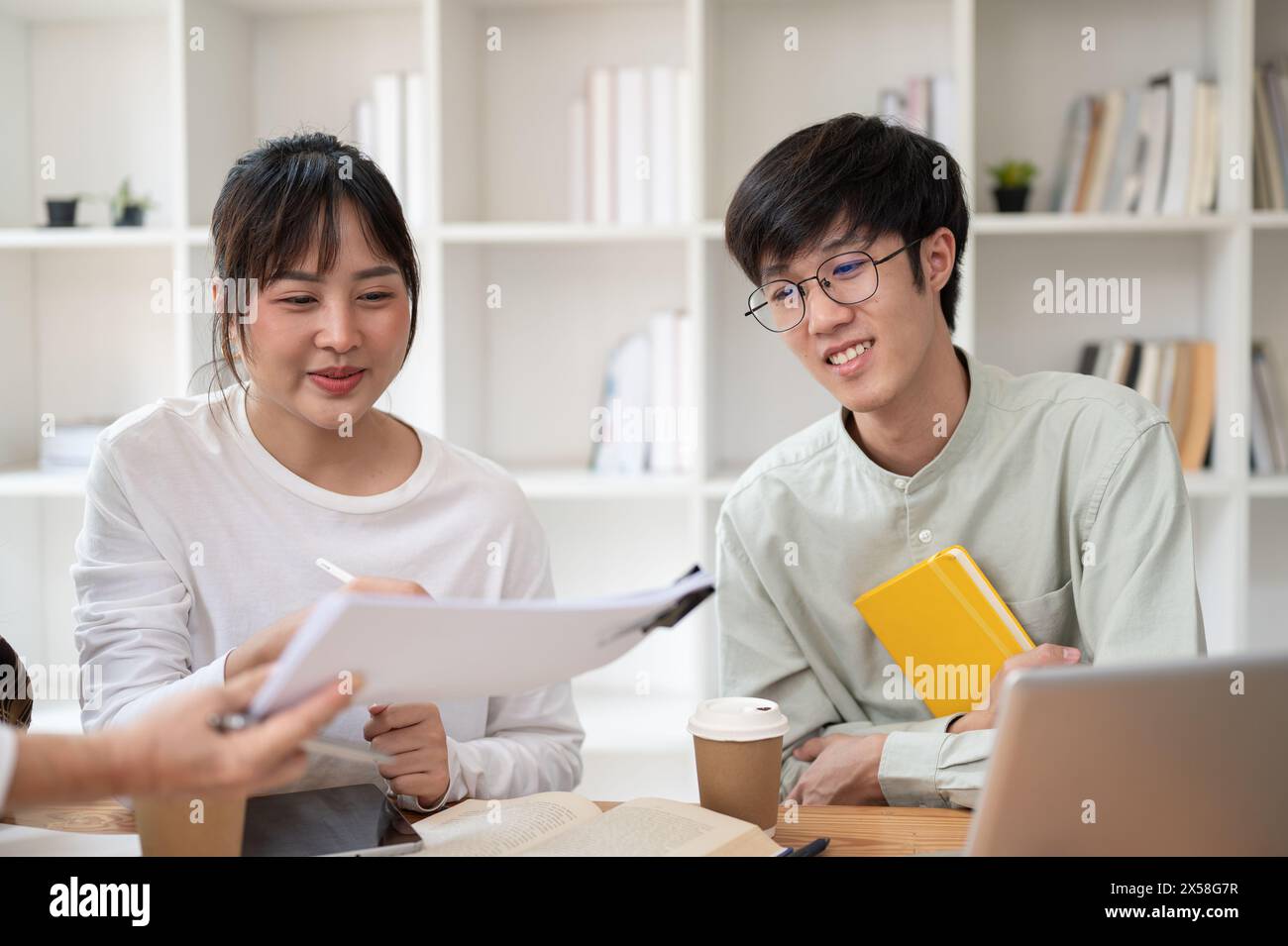 A group of cheerful Asian college students is enjoying studying math ...